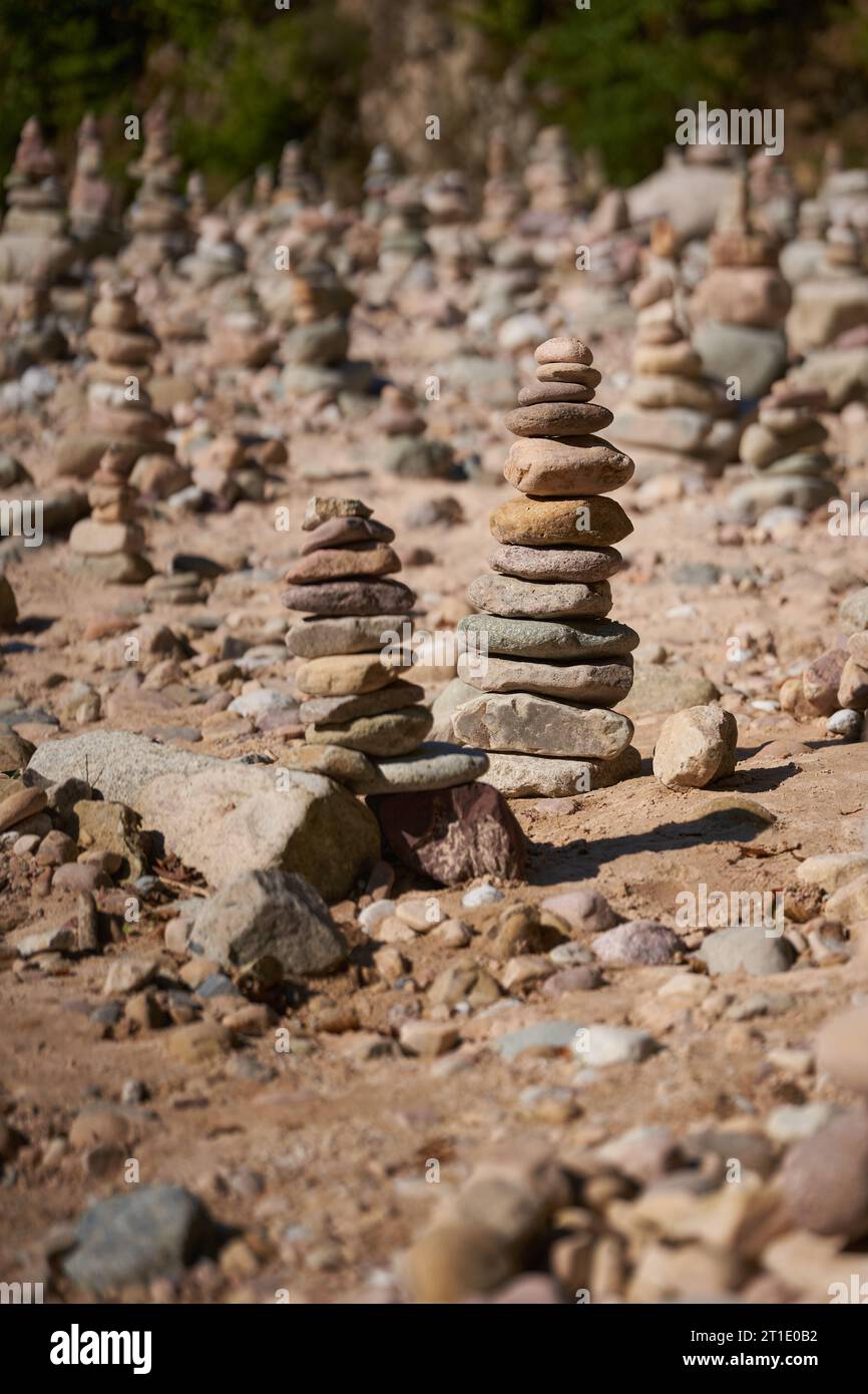 River pebbles and stones arranged in tower structures on the shore ...