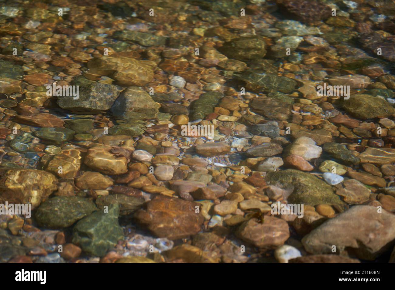 Colorful pebbles on the bottom of a river, seen through the water Stock ...