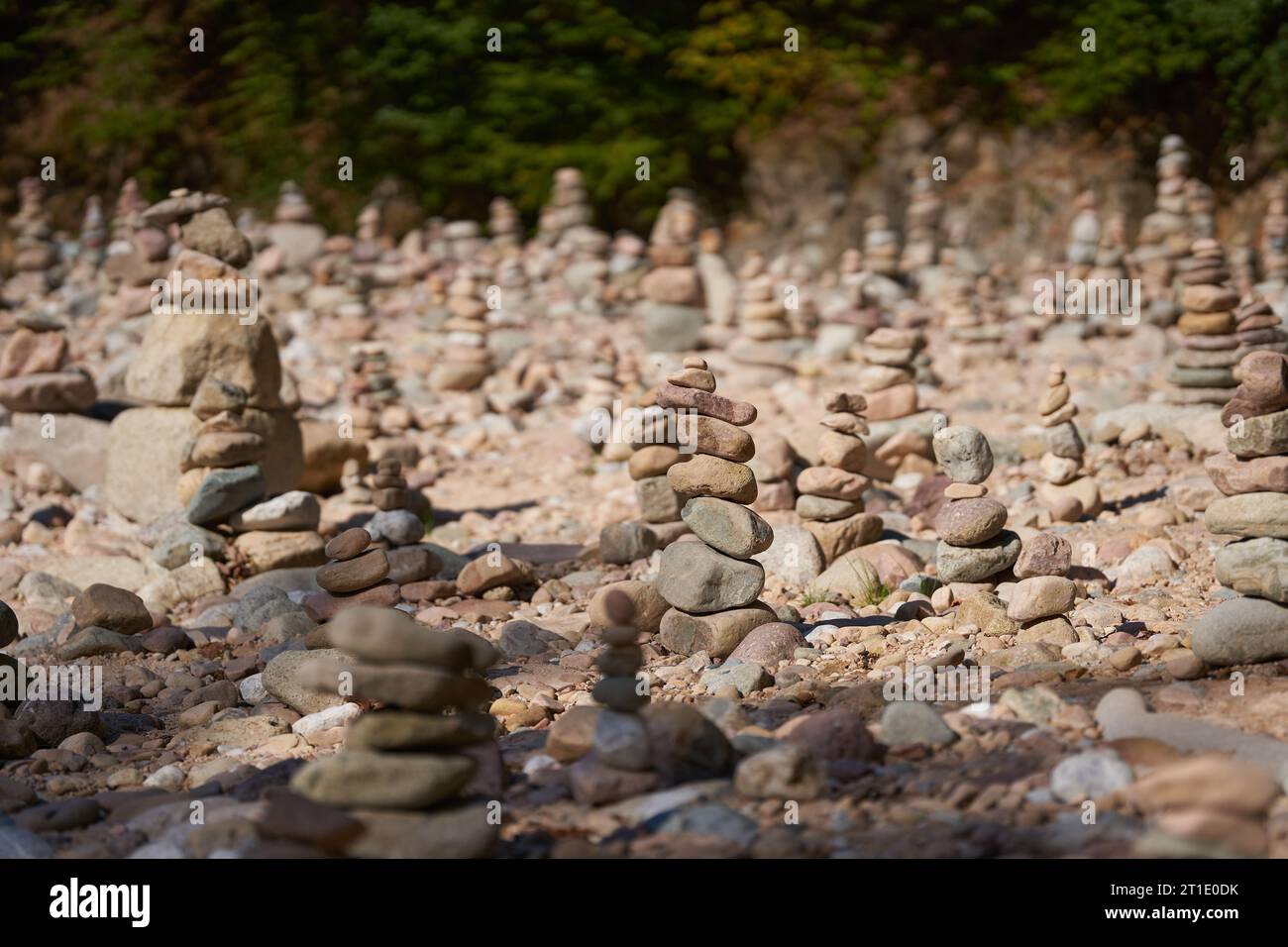 River pebbles and stones arranged in tower structures on the shore ...