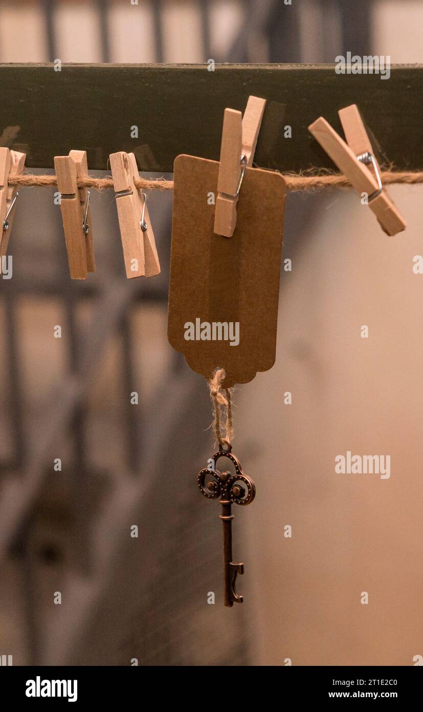 Old key with cardboard tag hanging on a string with clothespins ...