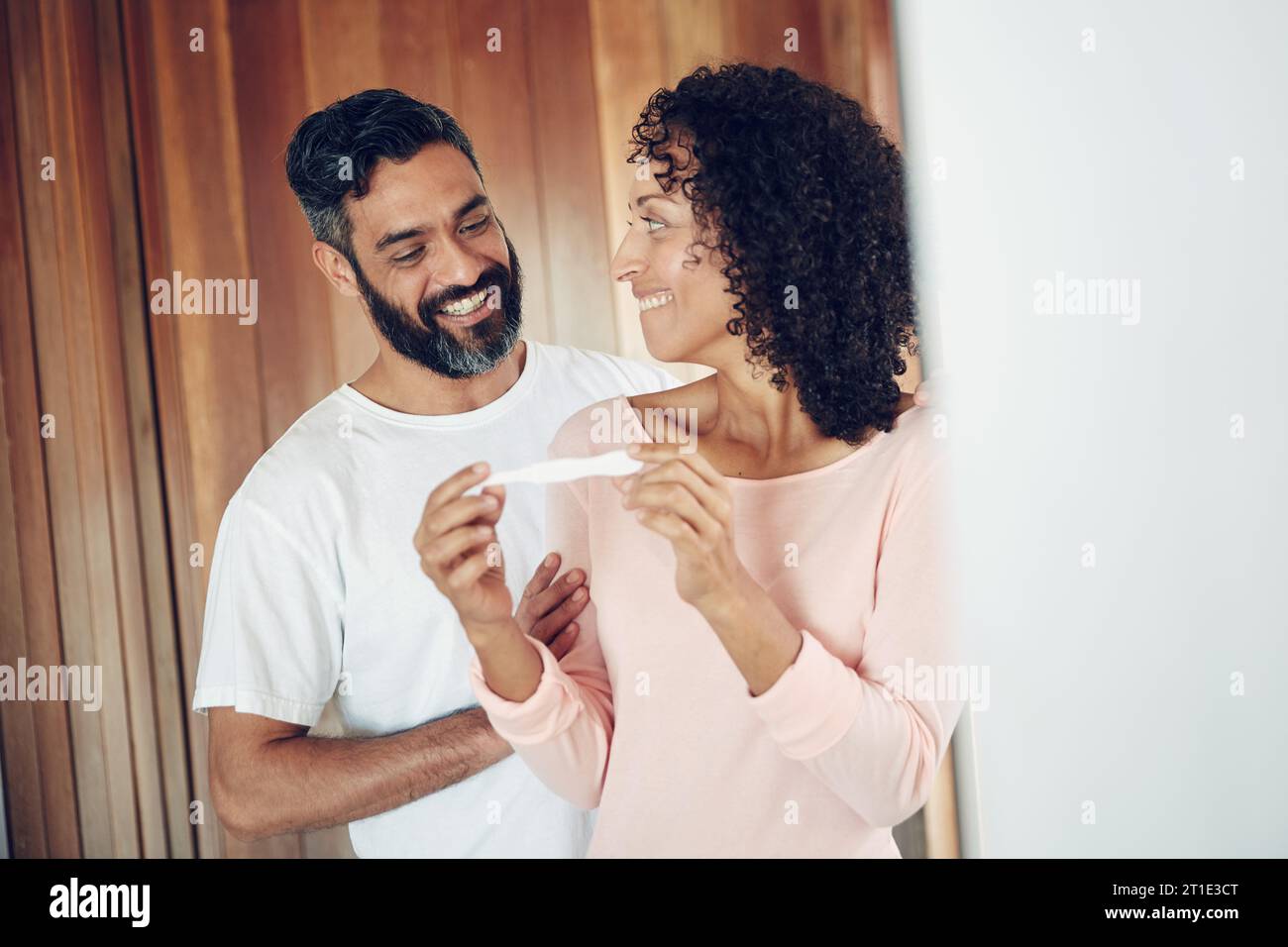 Couple, happy and positive pregnancy test at home, hug and excited for ...