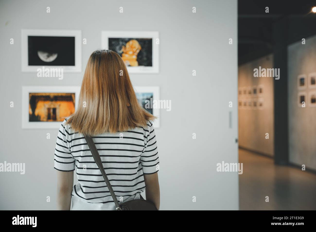 female watch at photo frame to leaning against at exhibit museum Stock ...