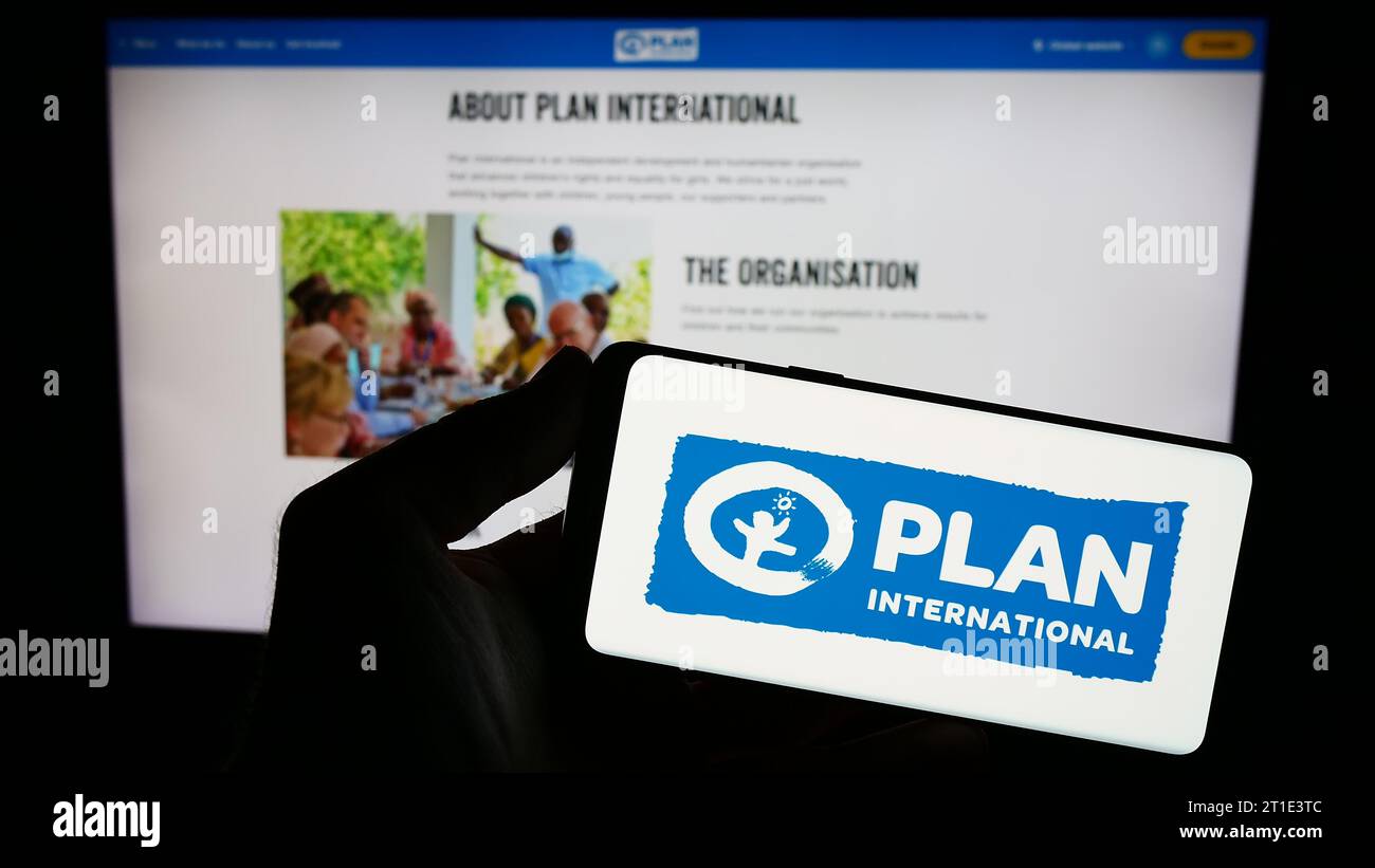 Person holding smartphone with logo of development organization Plan ...