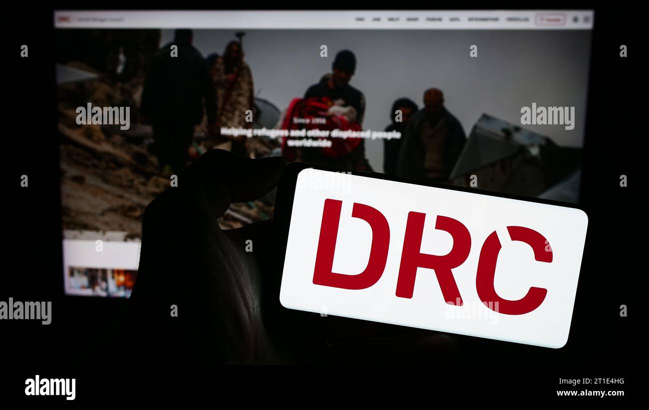 Person holding cellphone with logo of humanitarian organization Danish ...