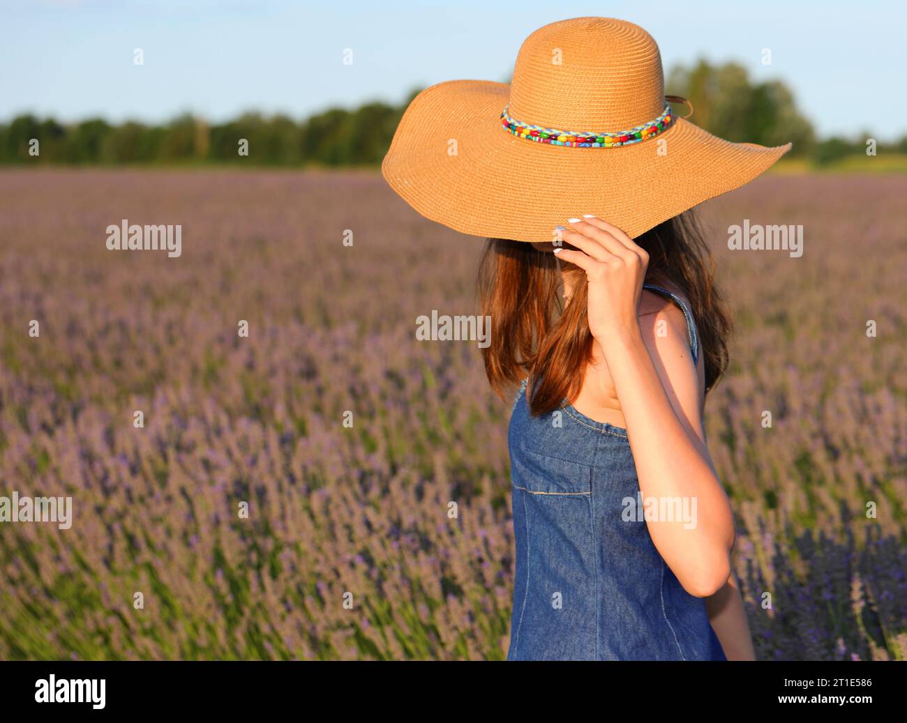 young slender top model girl in jeans dress and miniskirt and straw hat ...