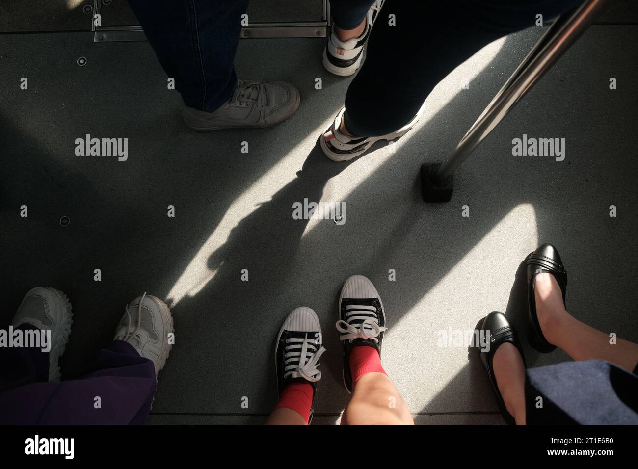 Feet of commuters with different footwear standing inside a train ...
