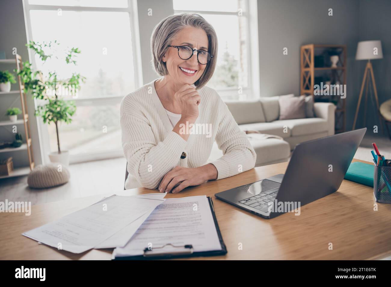 Photo of sweet clever senior lady broker dressed white cardigan reading ...