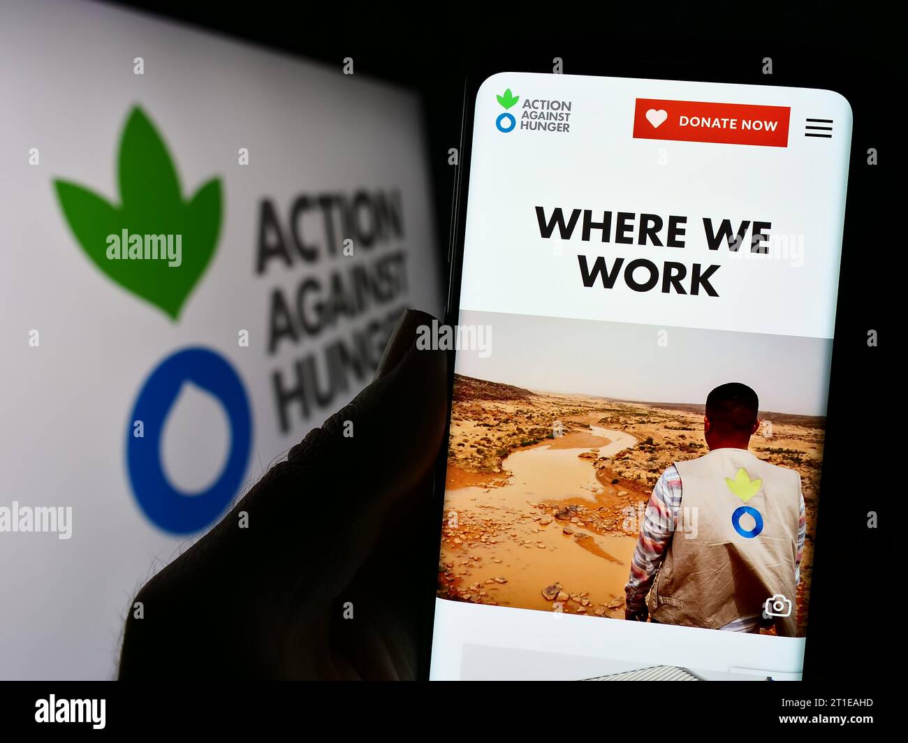 Person holding cellphone with webpage of humanitarian organization ...