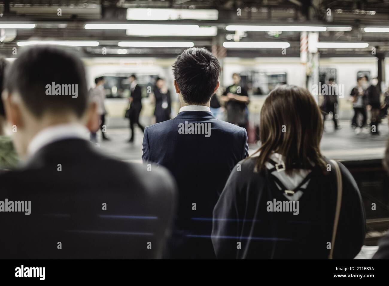 Passengers traveling by Tokyo metro. Business people commuting to work by public transport in ...