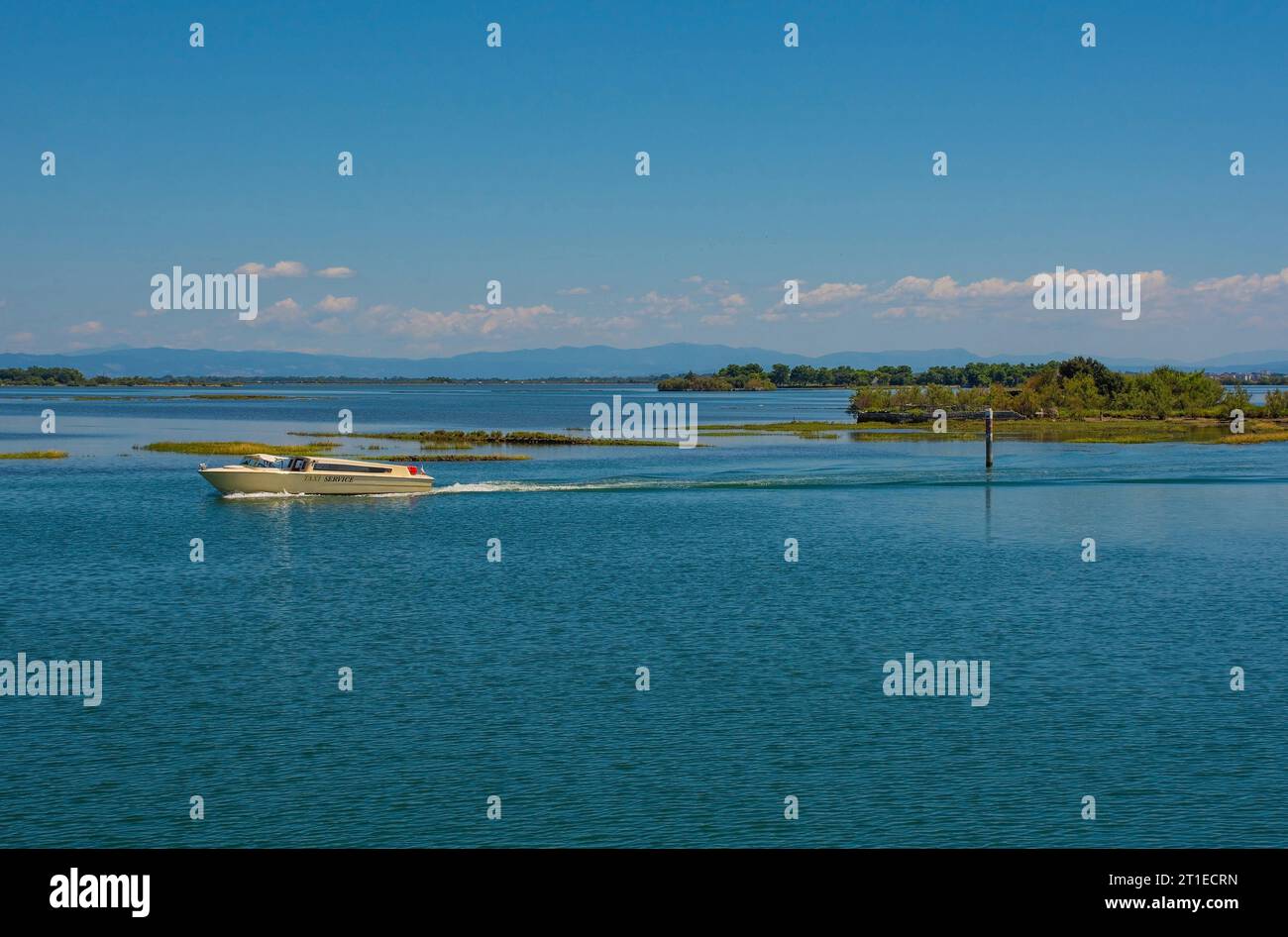 A water taxi crosses the shallow waters of the Grado section of the ...