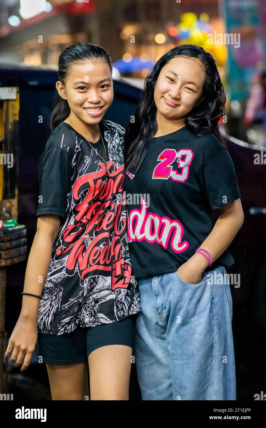 Two young pretty Filipino girls pose and smile for their portrait in ...