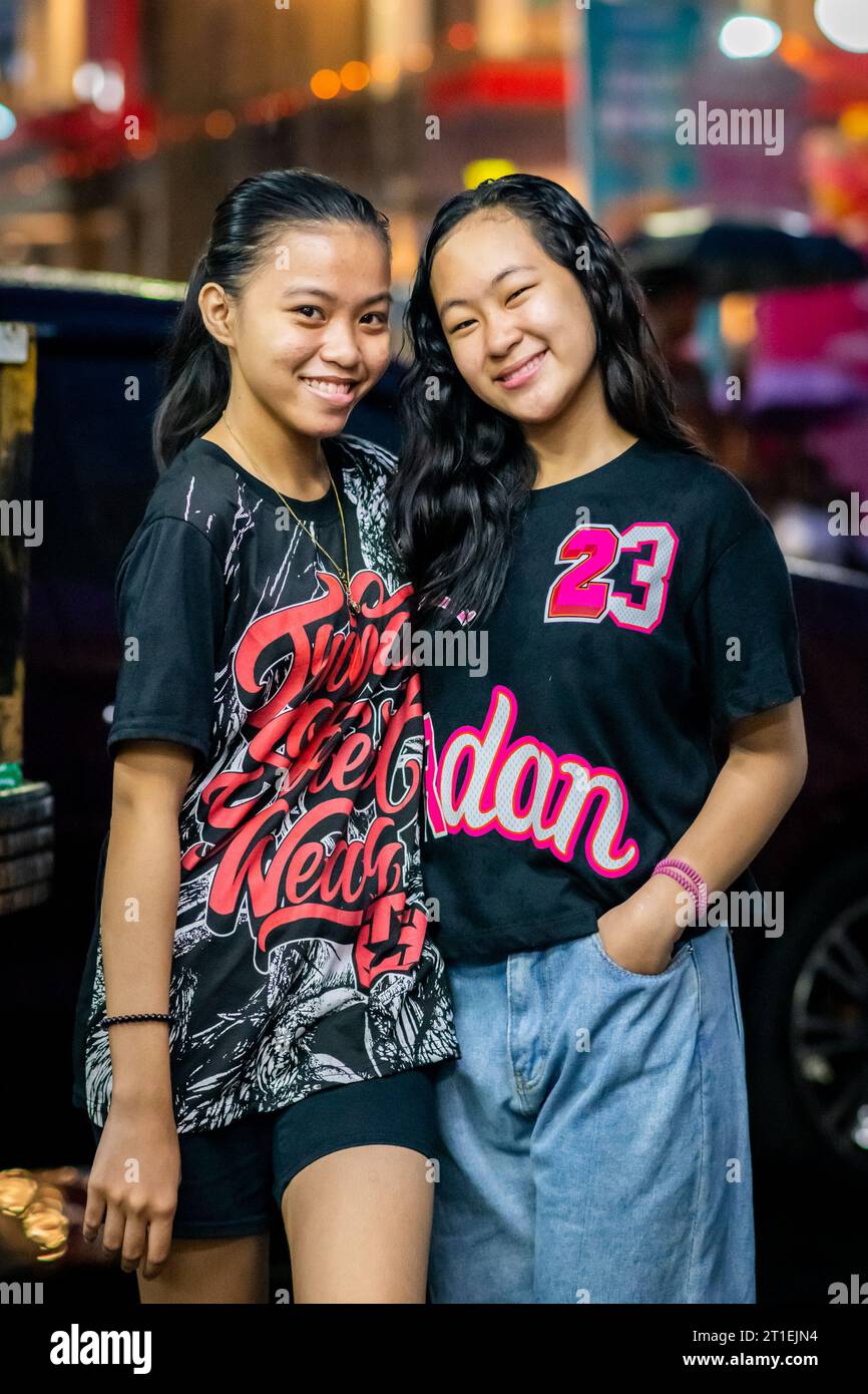 Two young pretty Filipino girls pose and smile for their portrait in ...