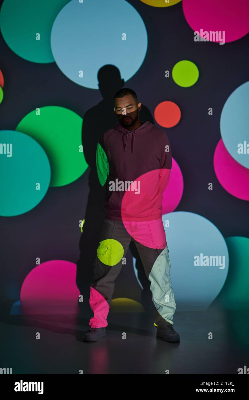 stylish man with beard and hands behind back posing in digital ...