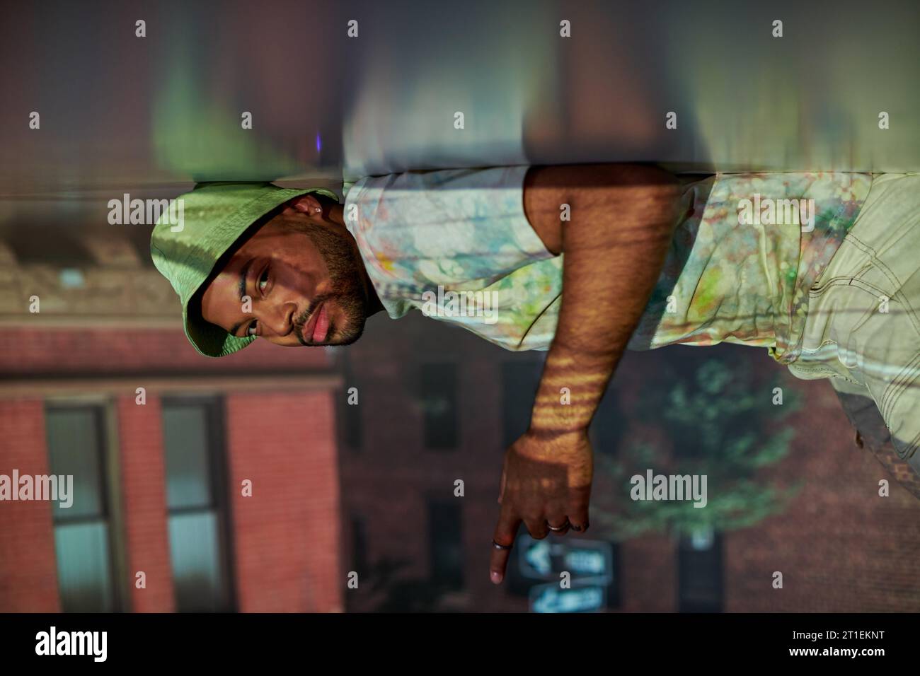 trendy african american man in casual attire lying on floor in ...