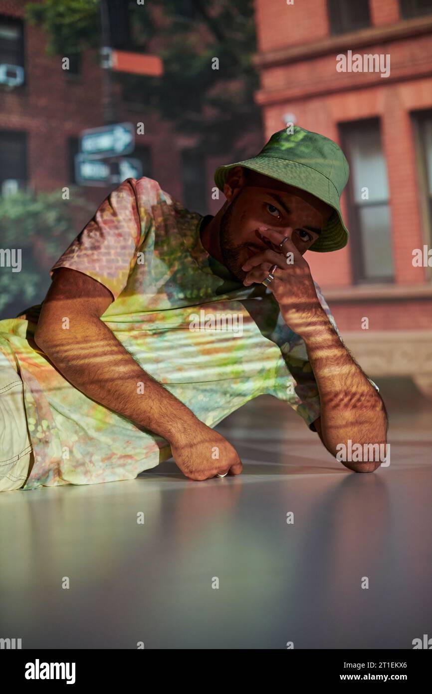 good looking man half lying on floor in stylish outfit in digital ...