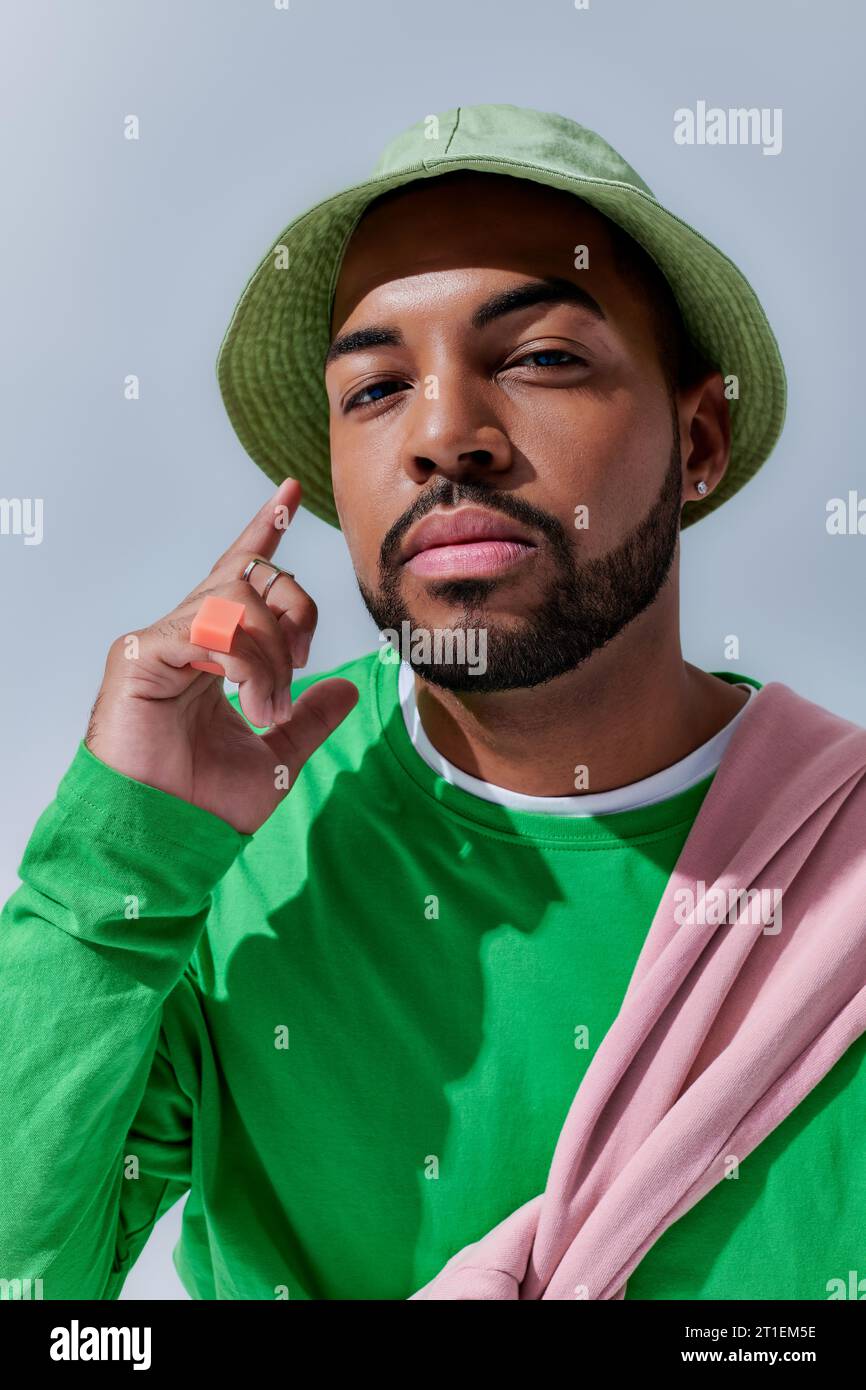 handsome young male model with finger near face pointing up looking at ...