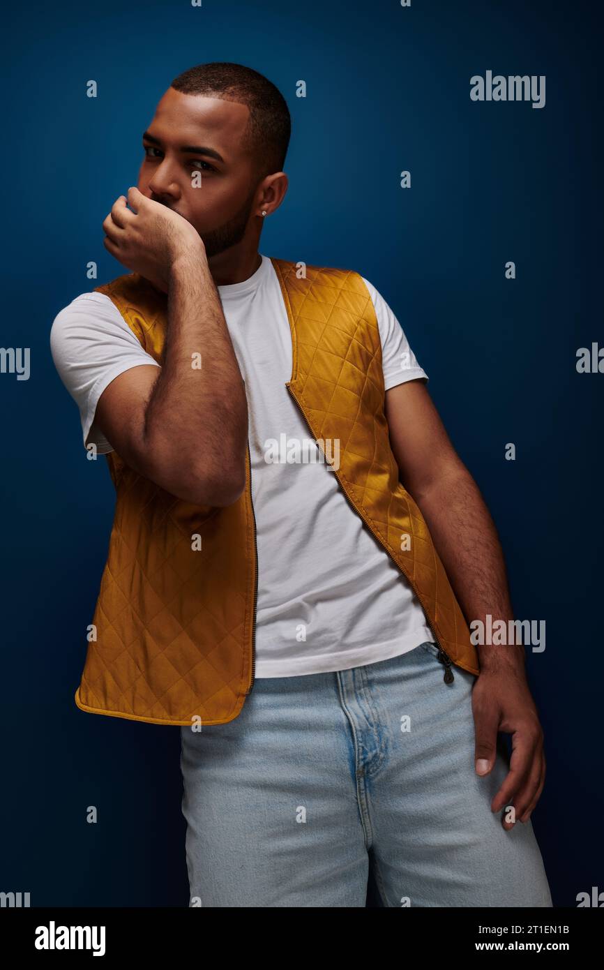 young african american male model in yellow vest posing with his wrist ...