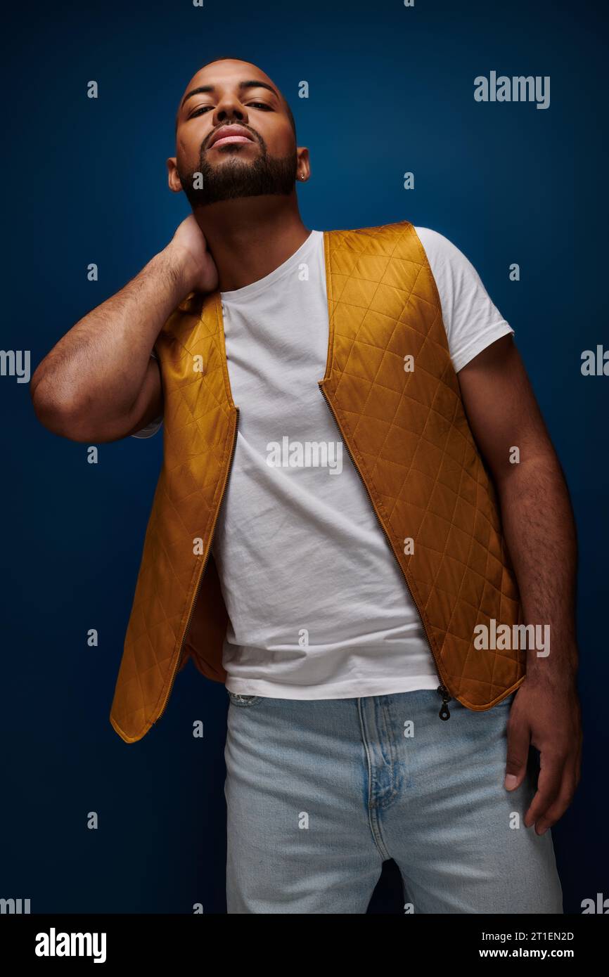 handsome african american man in yellow vest posing with his hand ...