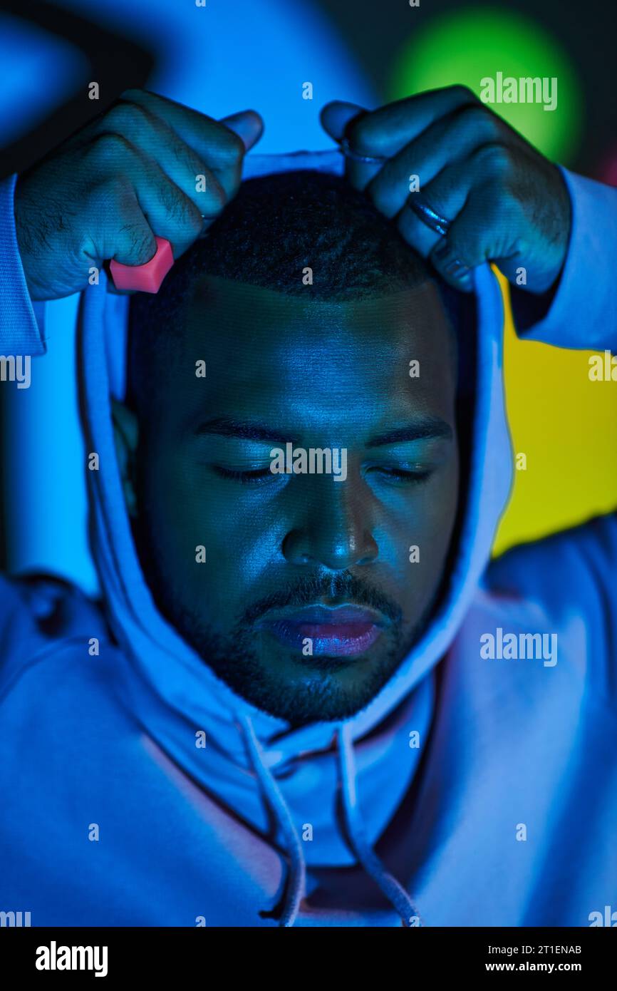 portrait of african american man putting on hood in digital projector ...