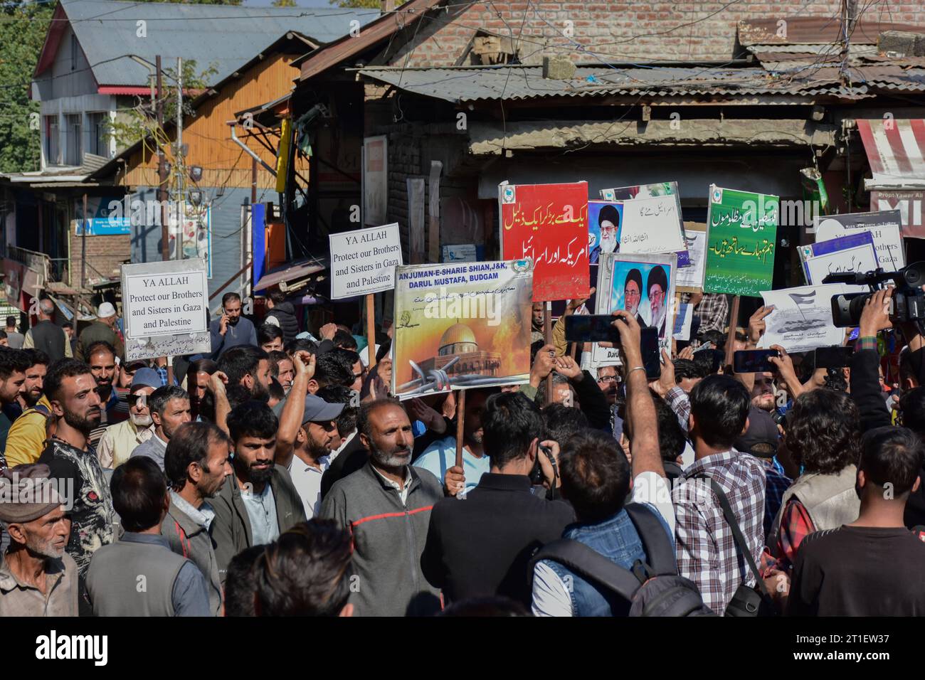 Budgam, India. 13th Oct, 2023. Kashmiri Muslims hold placards as they ...