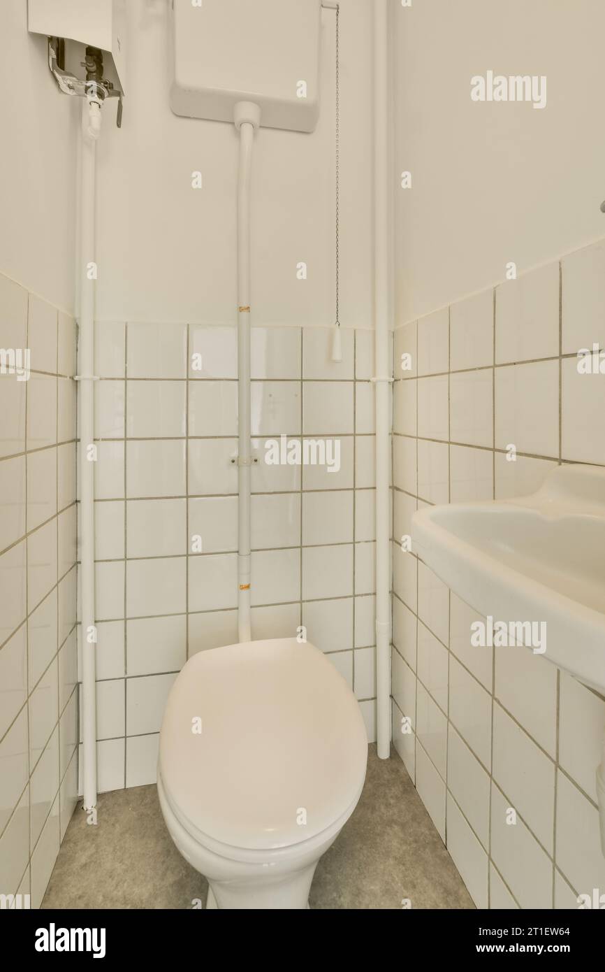 a white toilet in a bathroom with tile on the floor and walls, it is ...