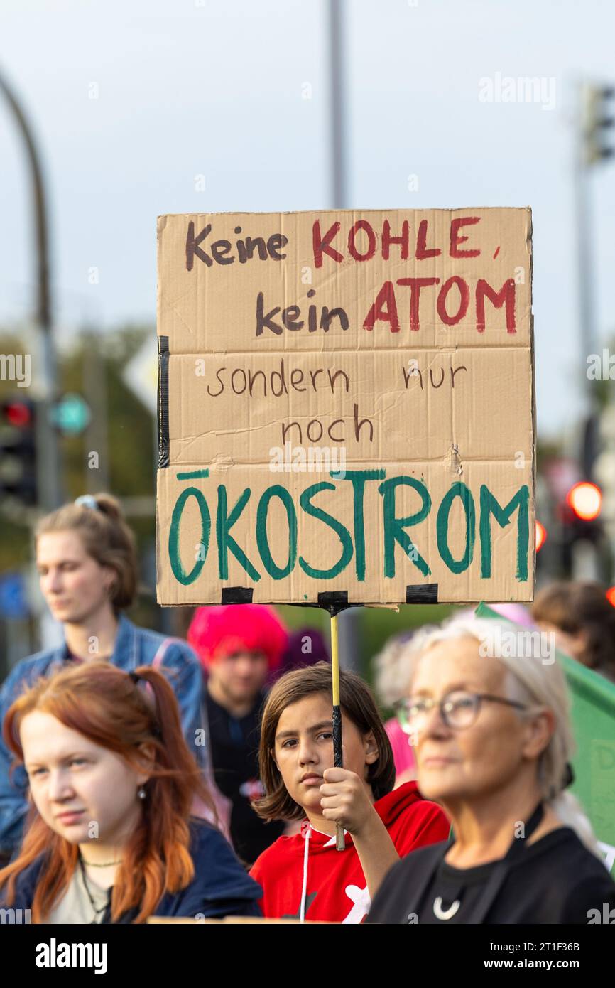 Dresden, Germany. 13th Oct, 2023. A young woman in a red shirt (center) holds up a sign reading ...