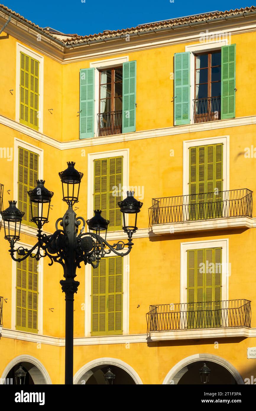 View of the yellow facades of old buildings with balconies and green ...