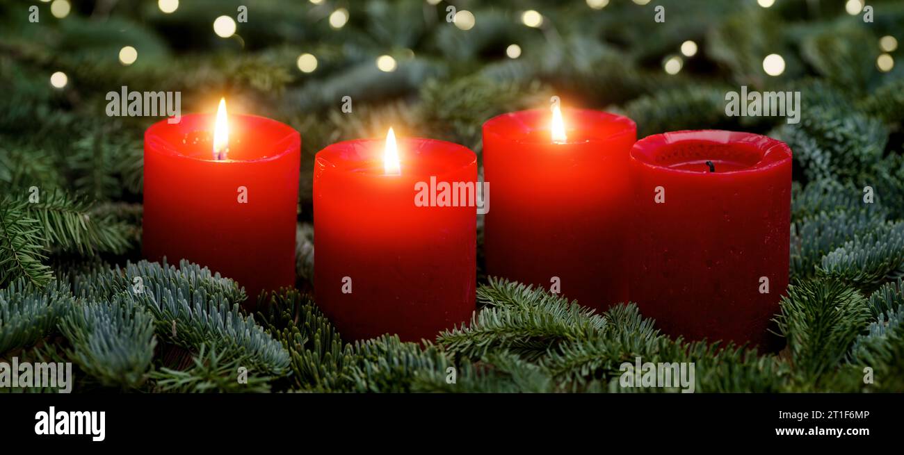 Red Advent candles, three burning, with fir branches and bokeh lights ... Red Advent candles, three burning, with fir branches and bokeh lights ...