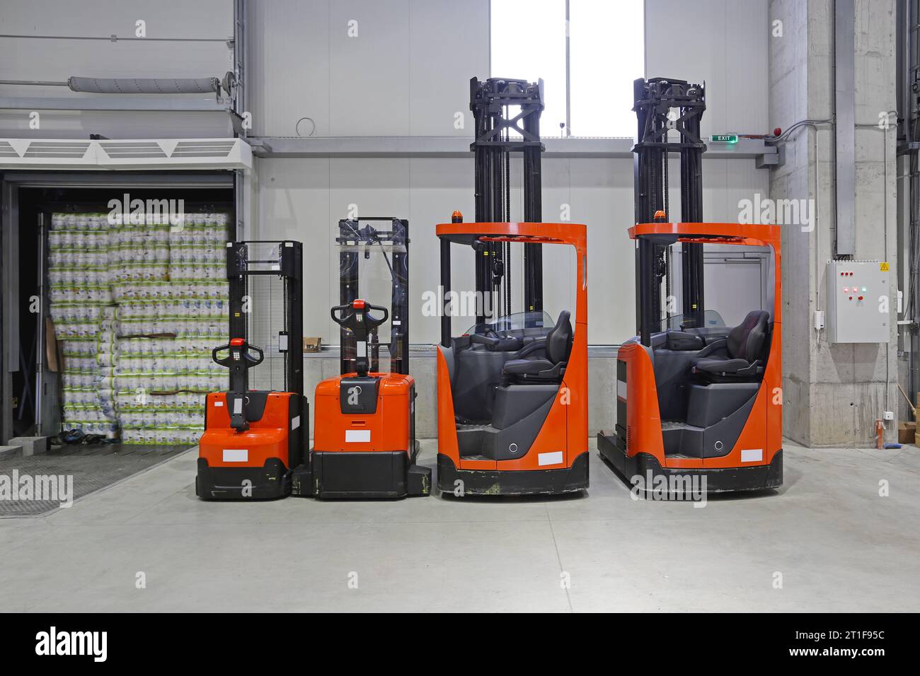 Four Vehicles Pallet Trucks and Forklifts in Distribution Warehouse ...