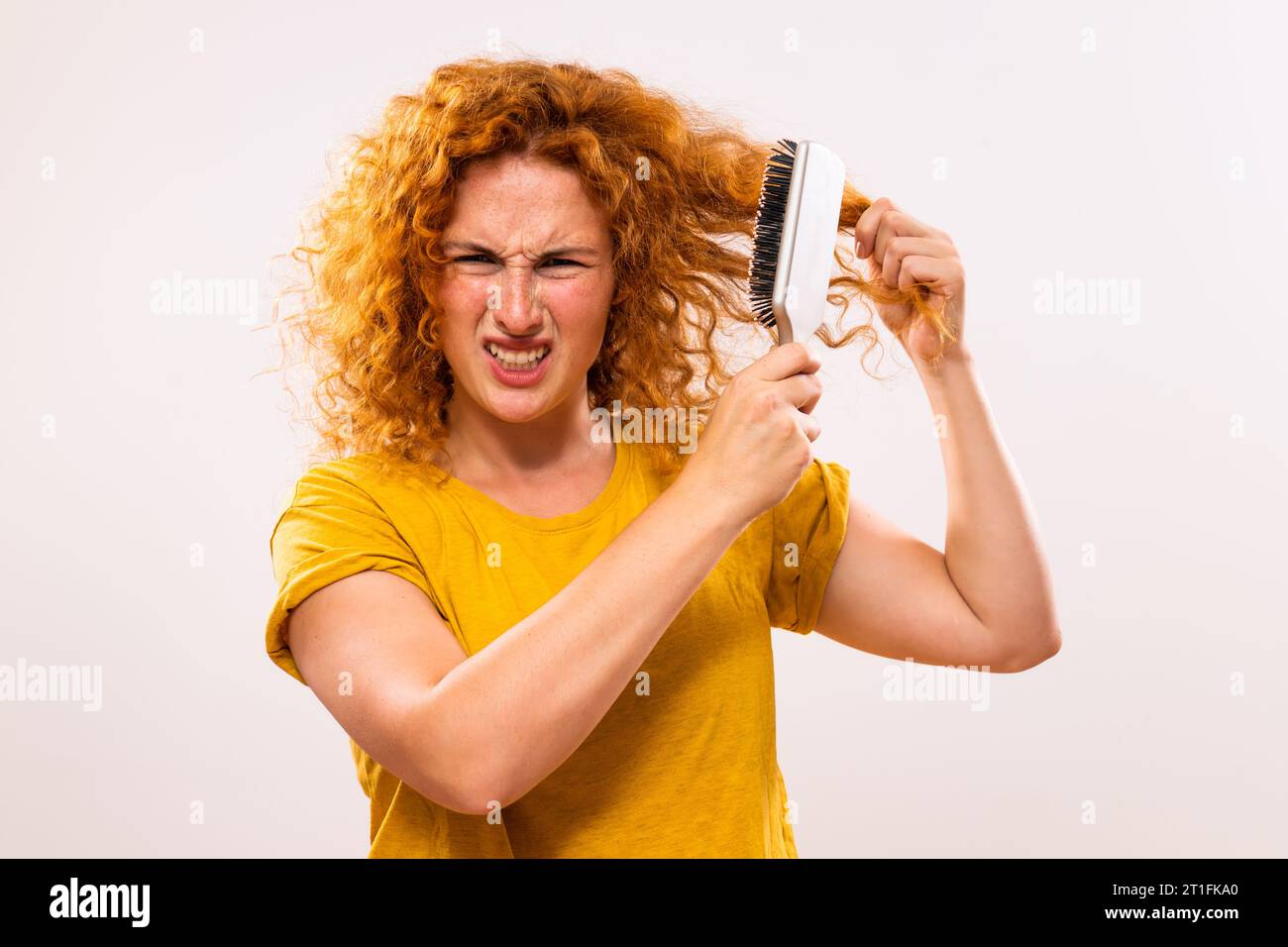 Angry woman combing tangled hair hi-res stock photography and images ...