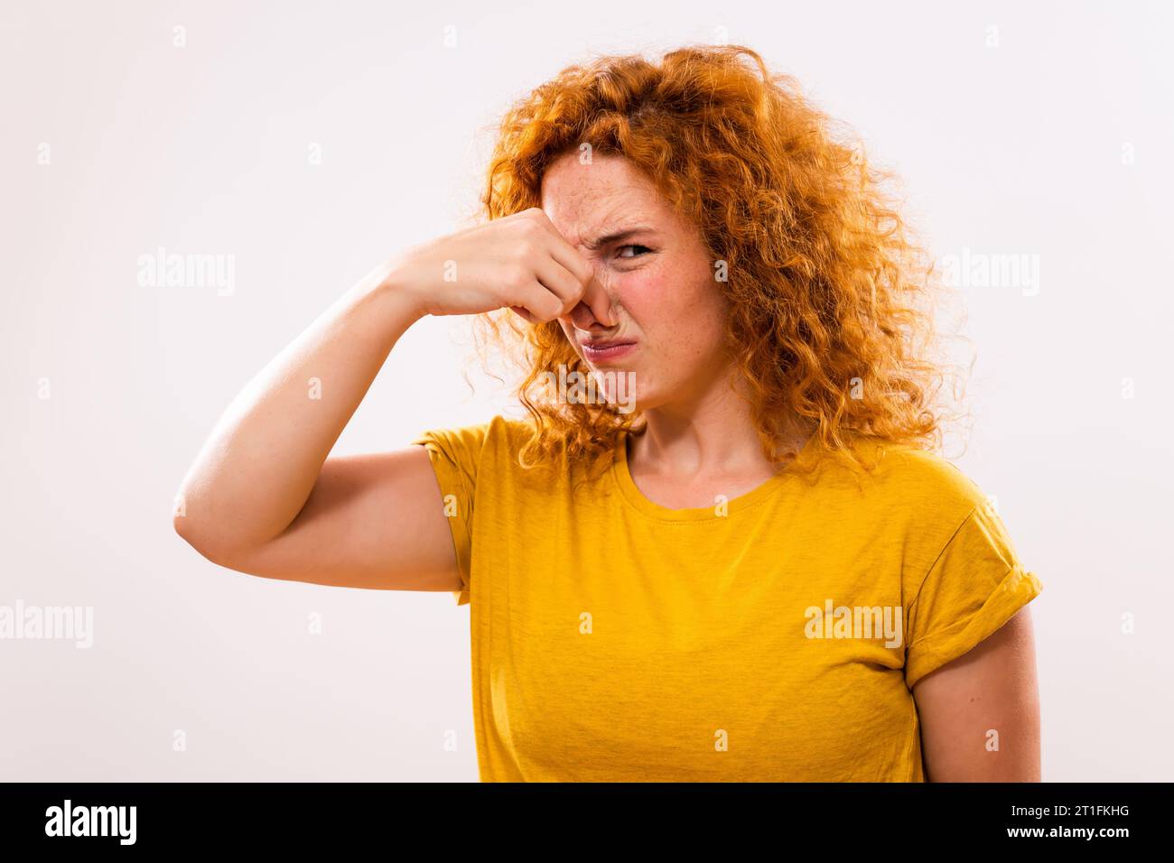 Shocked ginger woman doesn't like how something smells Stock Photo - Alamy
