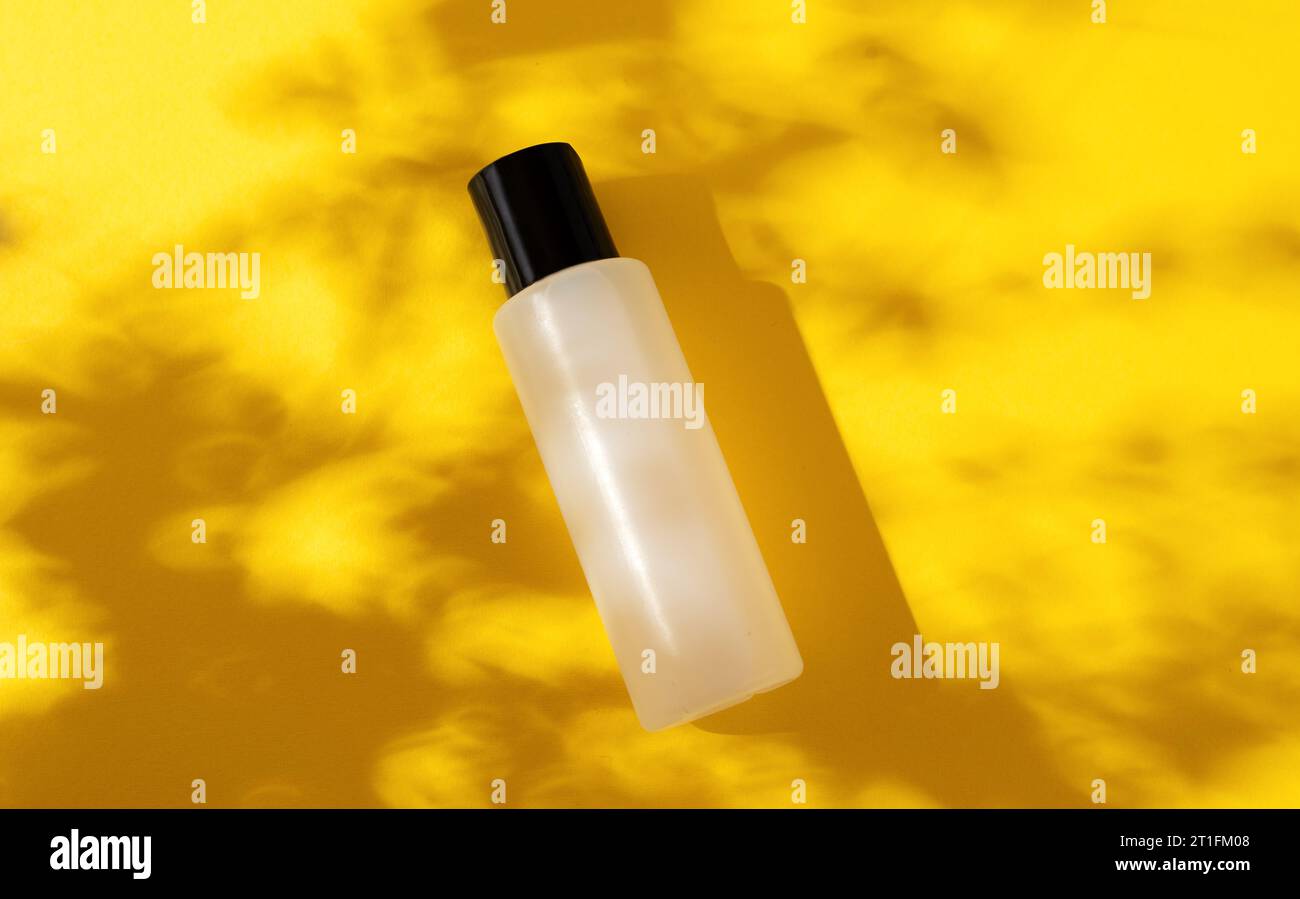 white bottle of cosmetic, shampoo, gel on a yellow background. Place ...