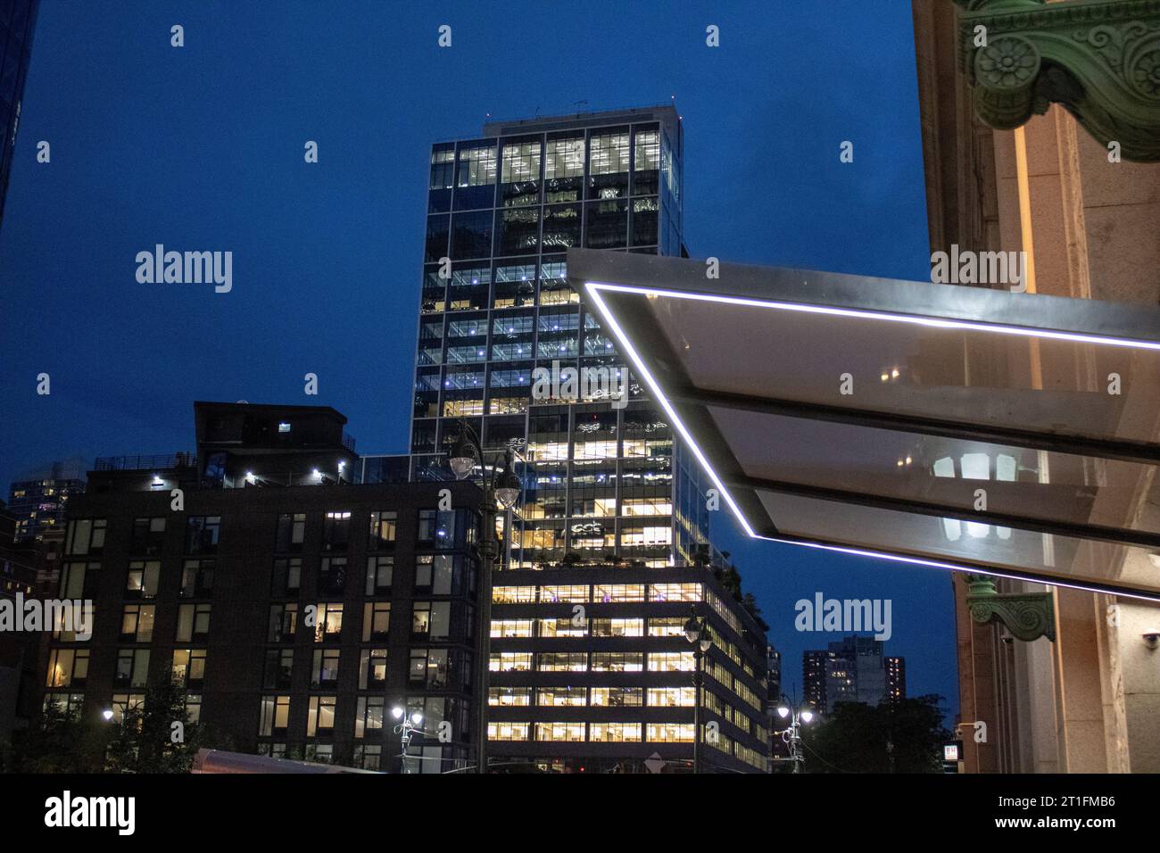 A vibrant nighttime street scene featuring a towering high-rise ...