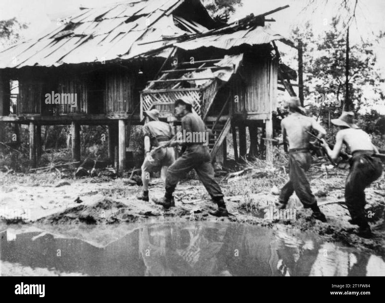 A British infantry patrol cautiously approaches a damaged building in a ...