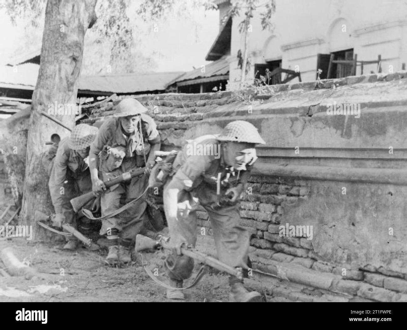 The British Army in Burma 1945 Troops crouch behind a low wall as they ...