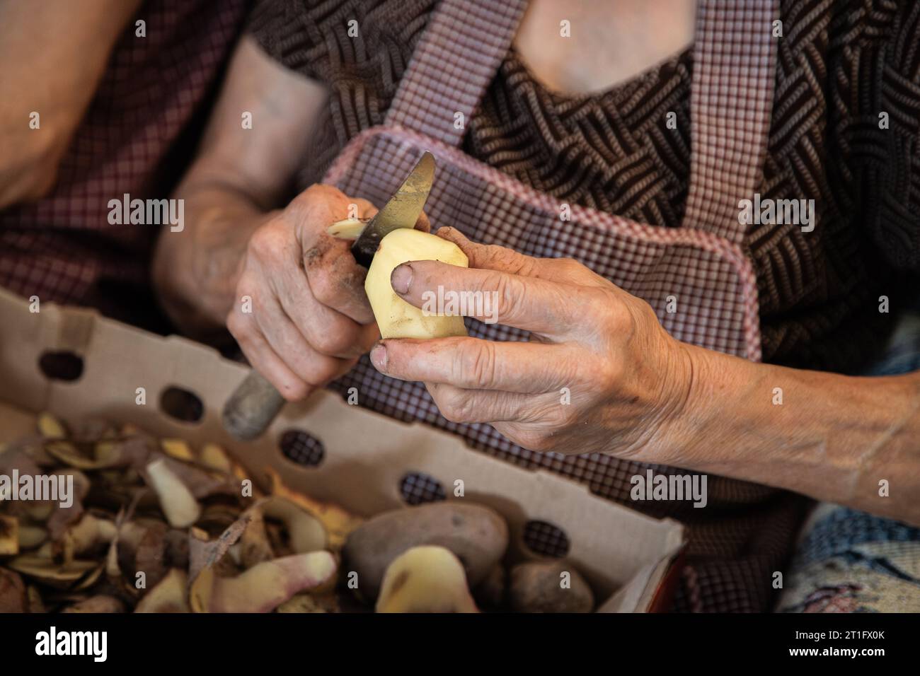 Elderly woman's hands doing domestic work of peeling potatoes. Aged ...