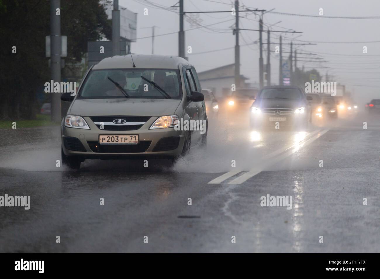cars moving on wet asphalt road during heavy rain fall at summer day in ...