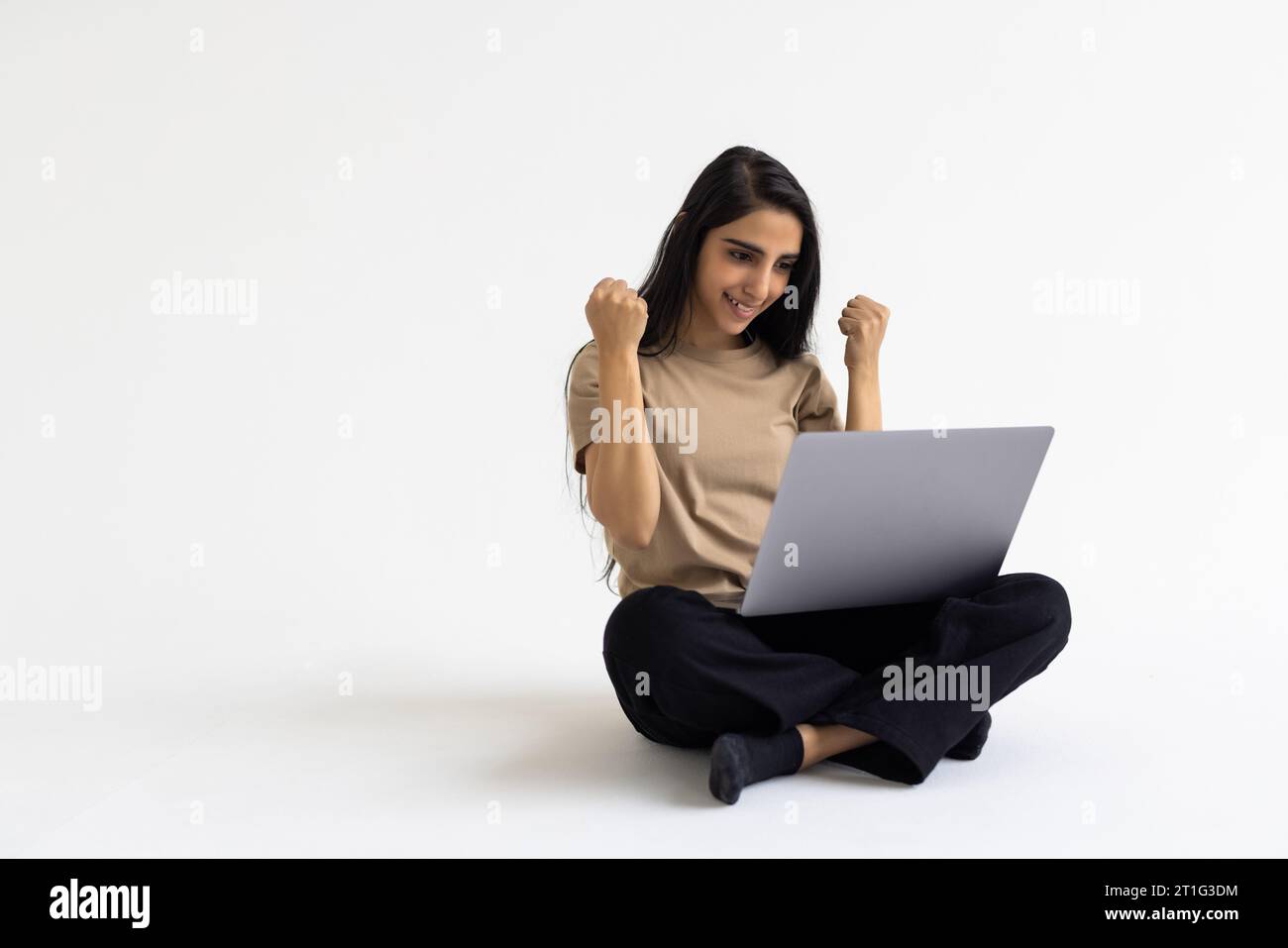 Indian corporate woman using laptop and giving winning expression on ...