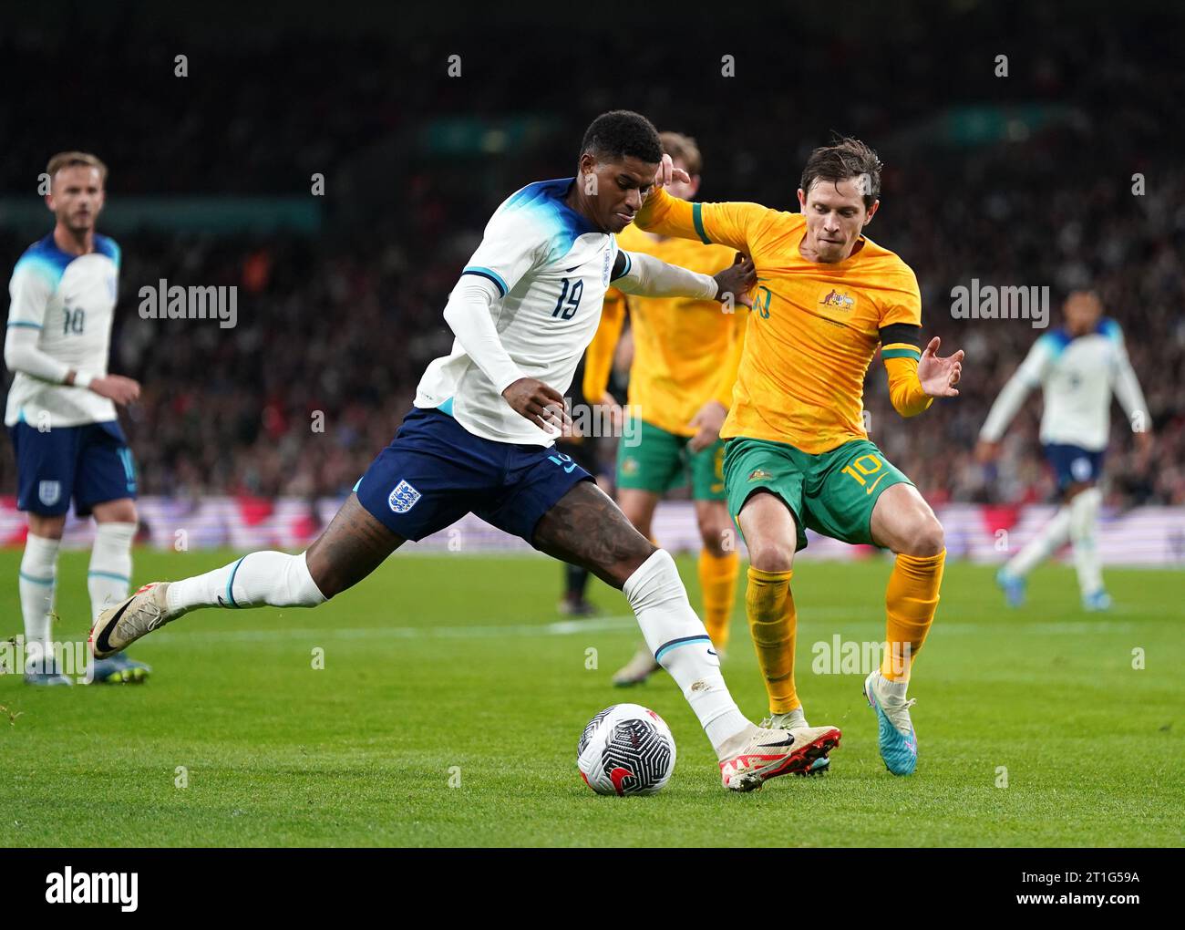 England's Marcus Rashford (left) and Australia's Craig Goodwin battle ...