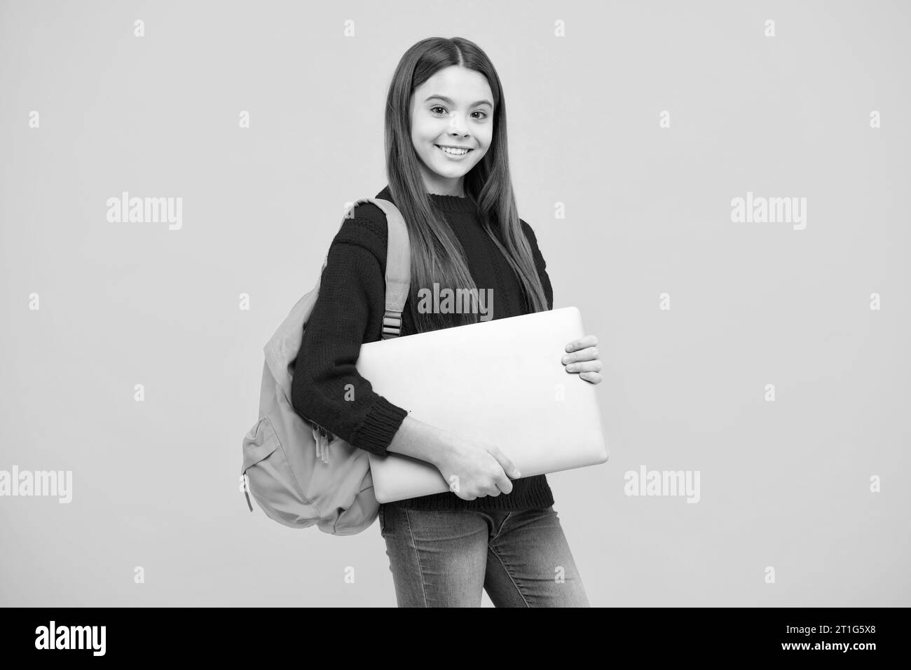 Teen schoolgirl hold laptop on isolated studio background. Cchool ...