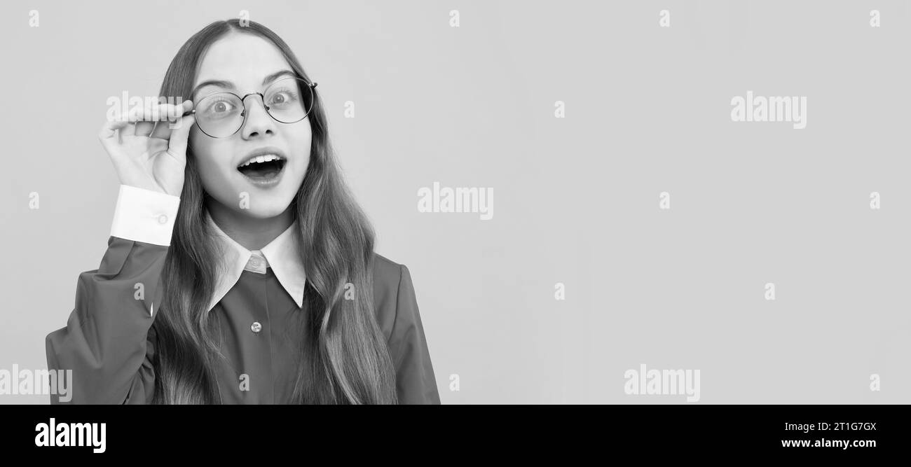 Curious school age girl child look through eyeglasses yellow background ...