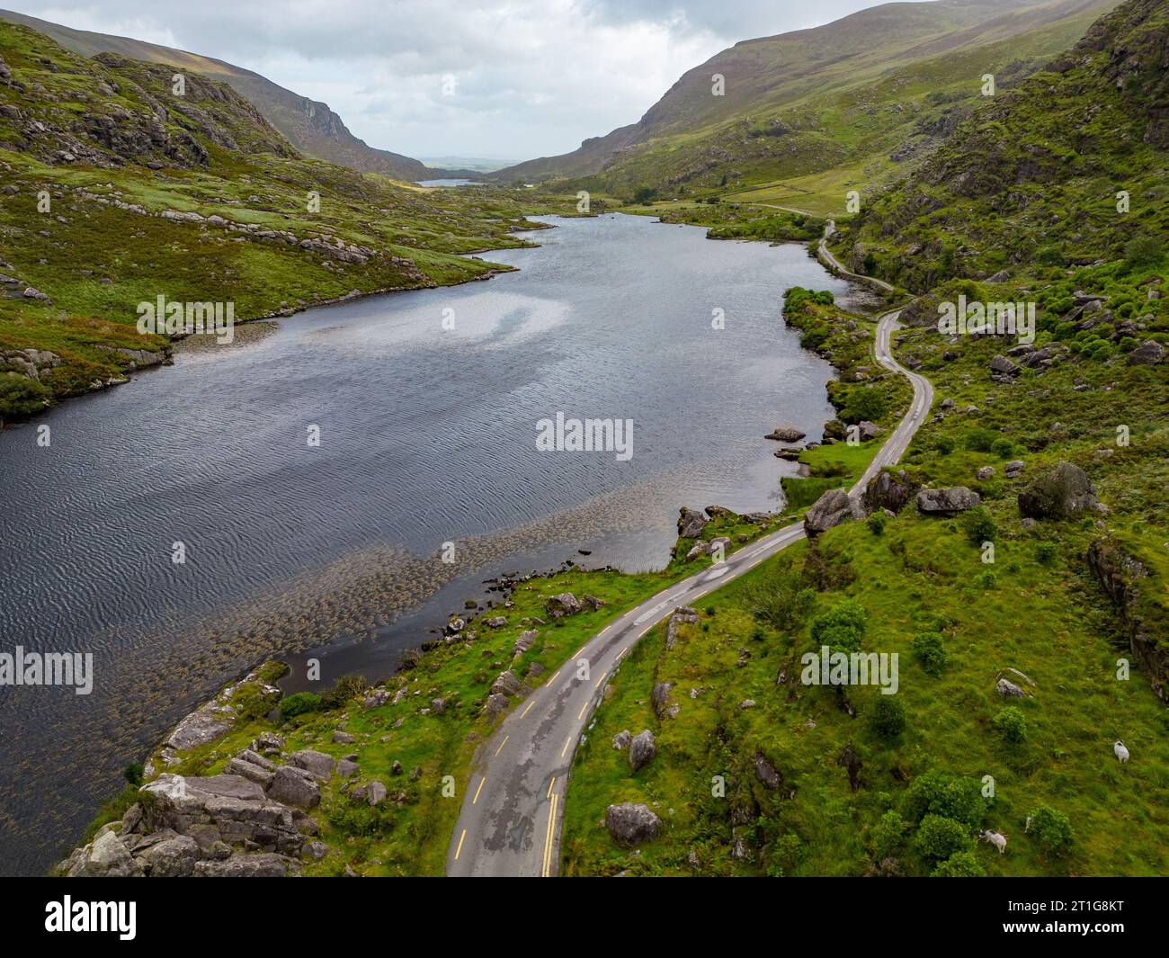 Aerial view of road and lake at Gap of Dunloe with rocks and vegetation ...