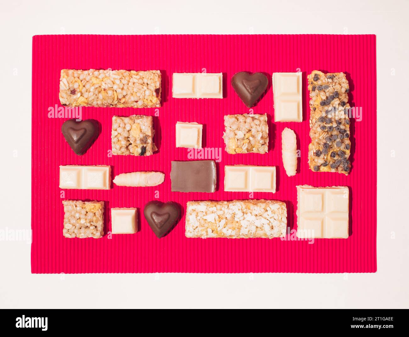 Creative layout from a chocolate and energy candies on a red background ...