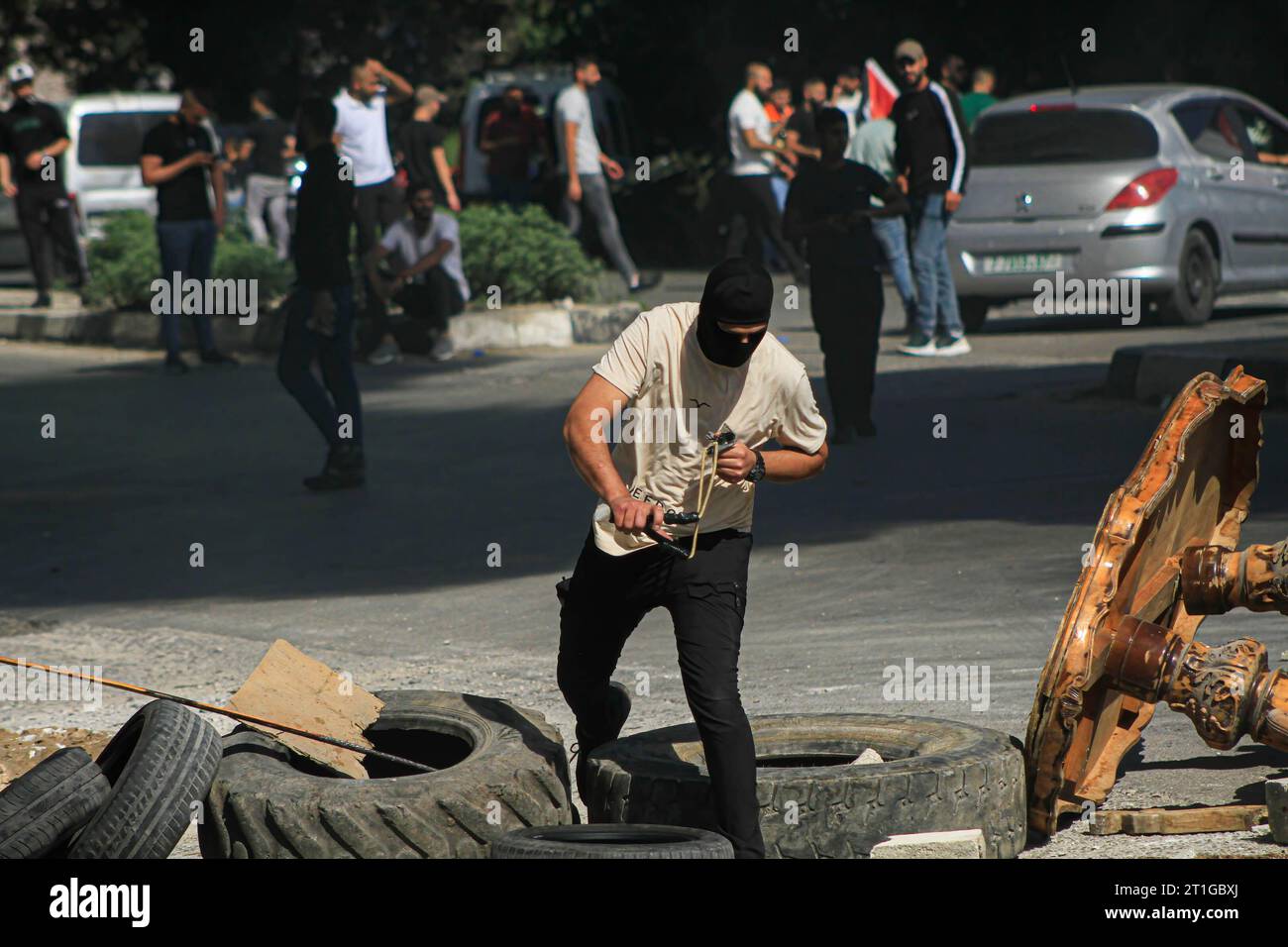 A Palestinian protester uses a slingshot to hurl stones at Israeli ...
