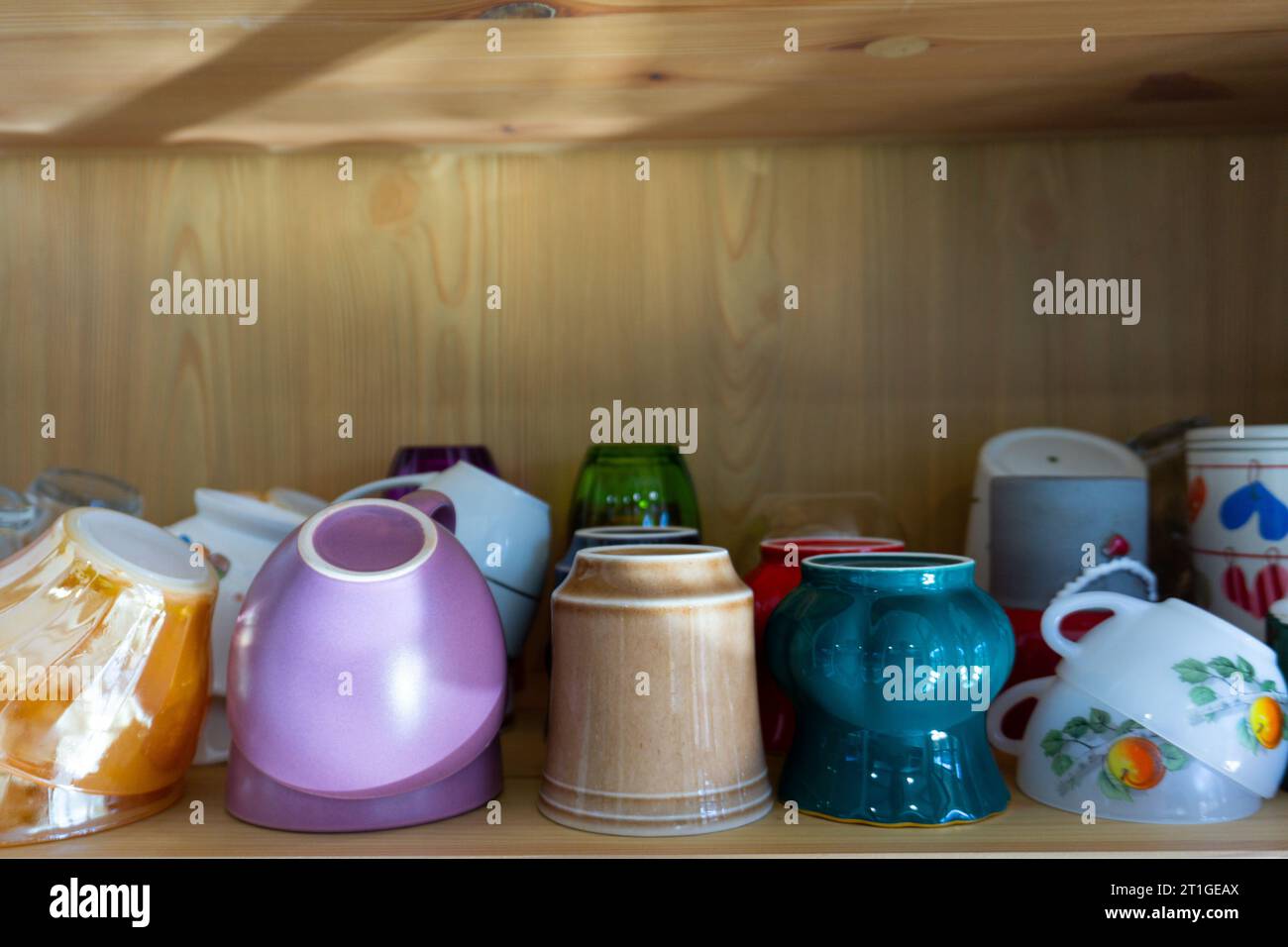 Cups in the kitchen cabinet. Colorful cups. Colorful cups used for tea ...