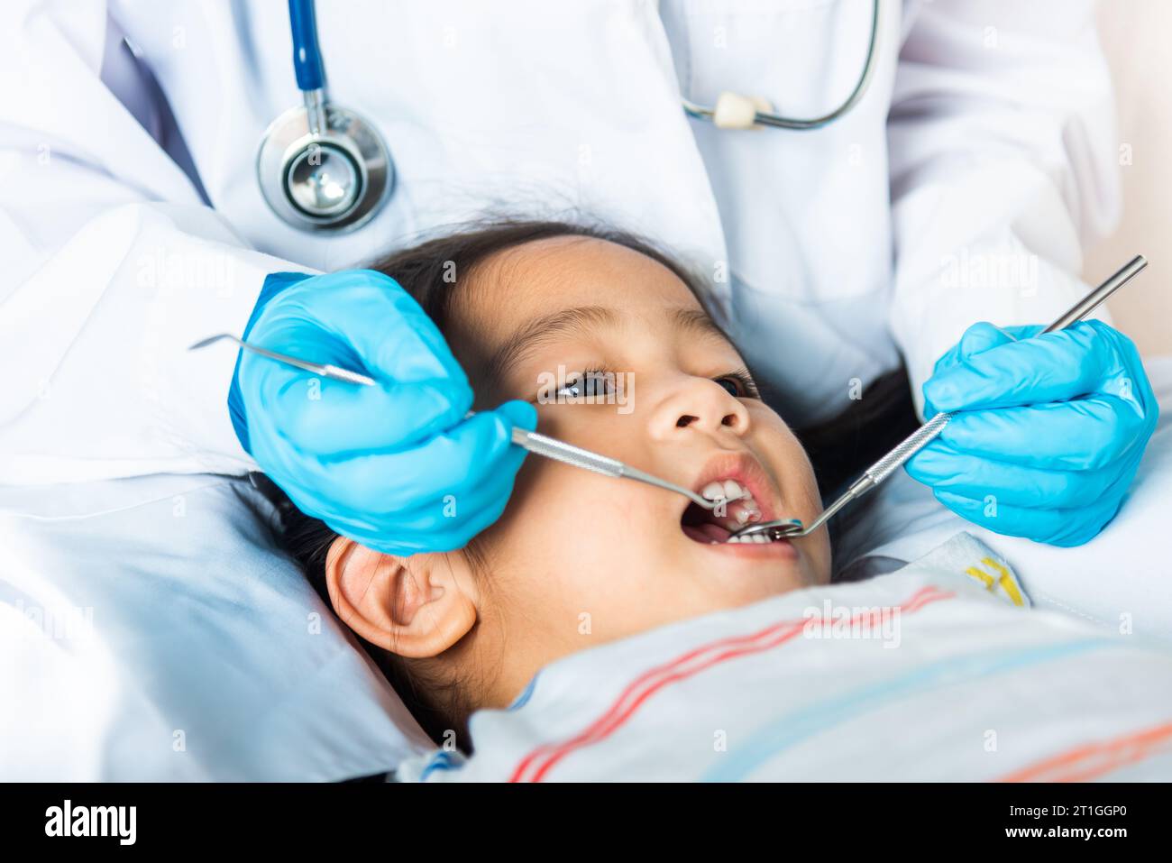 Doctor examines oral cavity of little child uses mouth mirror to ...