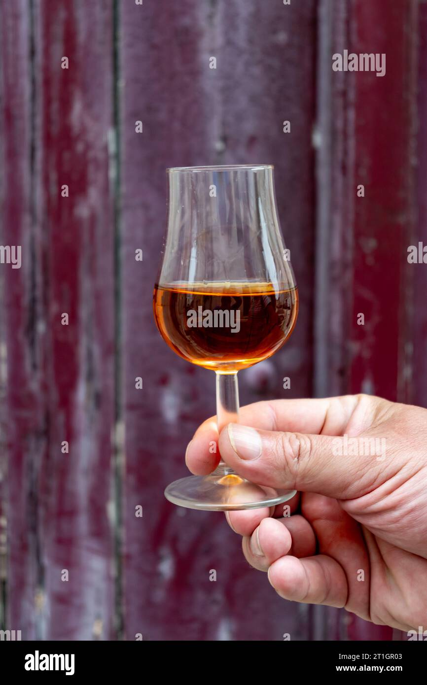 Tasting of aged in barrels cognac alcohol drink and view on old streets ...