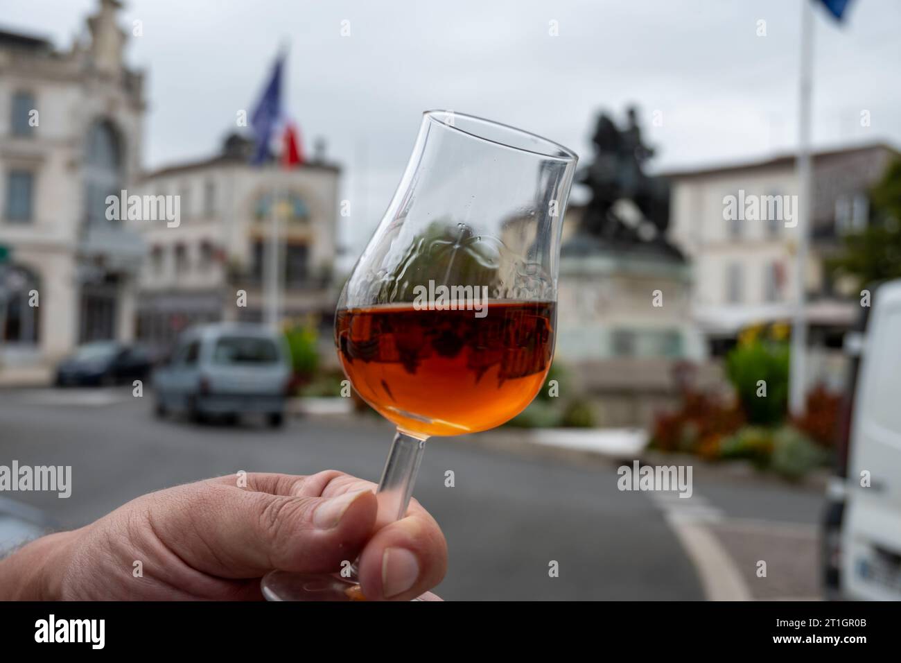 Tasting of aged in barrels cognac alcohol drink and view on old streets ...