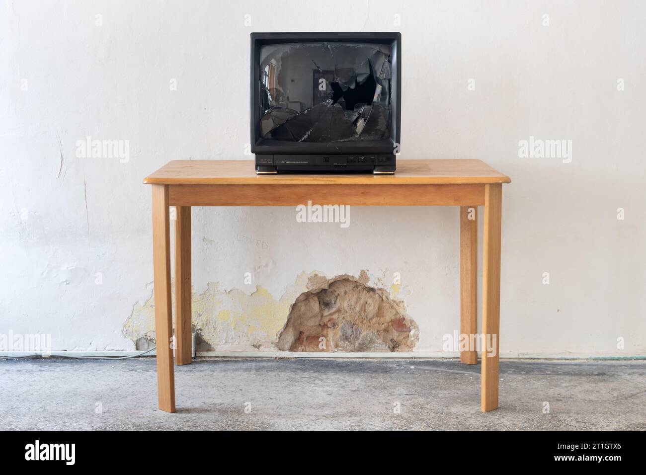 A broken television on a table in a desolate room Stock Photo - Alamy