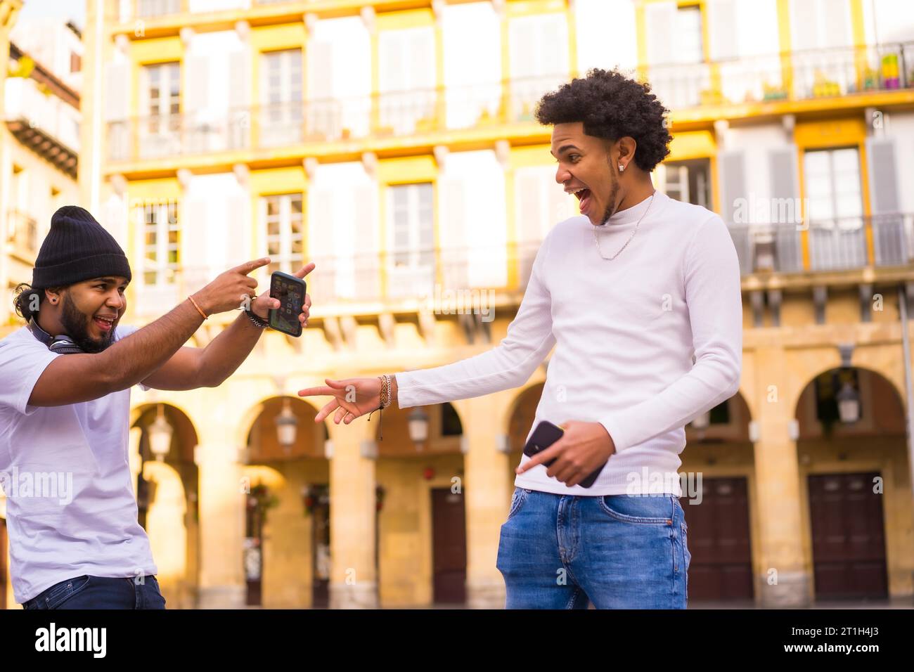 Lifestyle, two black Latino friends very happy to meet on the street a ...